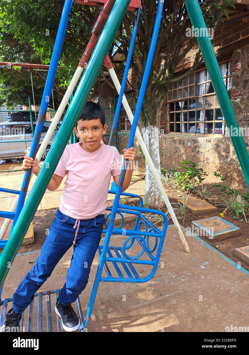 9-year-old dark-skinned Latino male child practices balance exercises ...