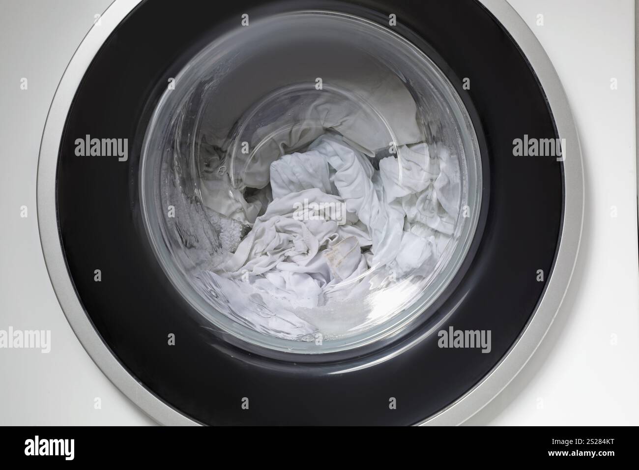 Washing machine with clothes as background, closeup Stock Photo - Alamy