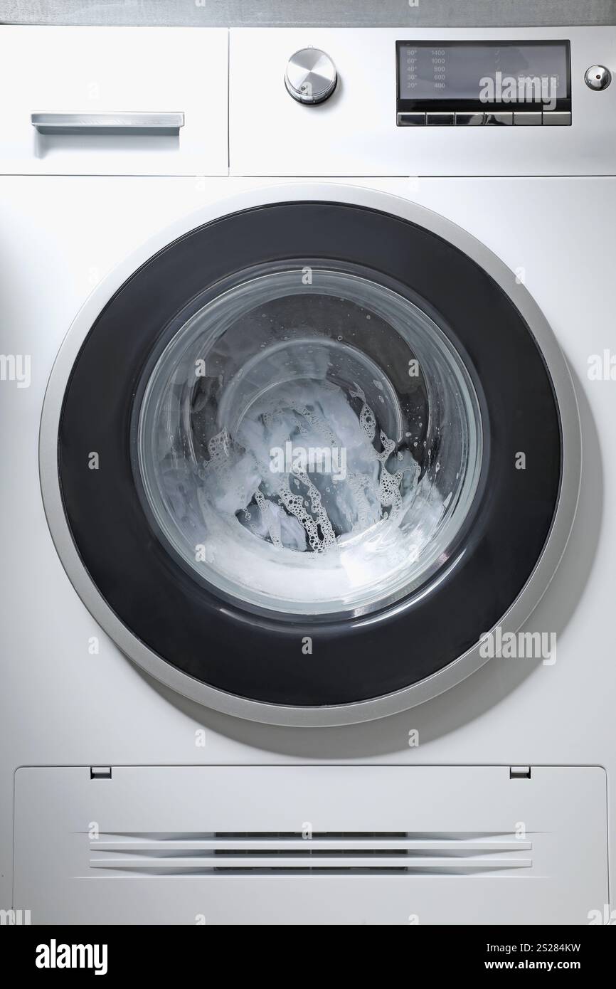 Washing machine with clothes and suds as background, closeup Stock ...