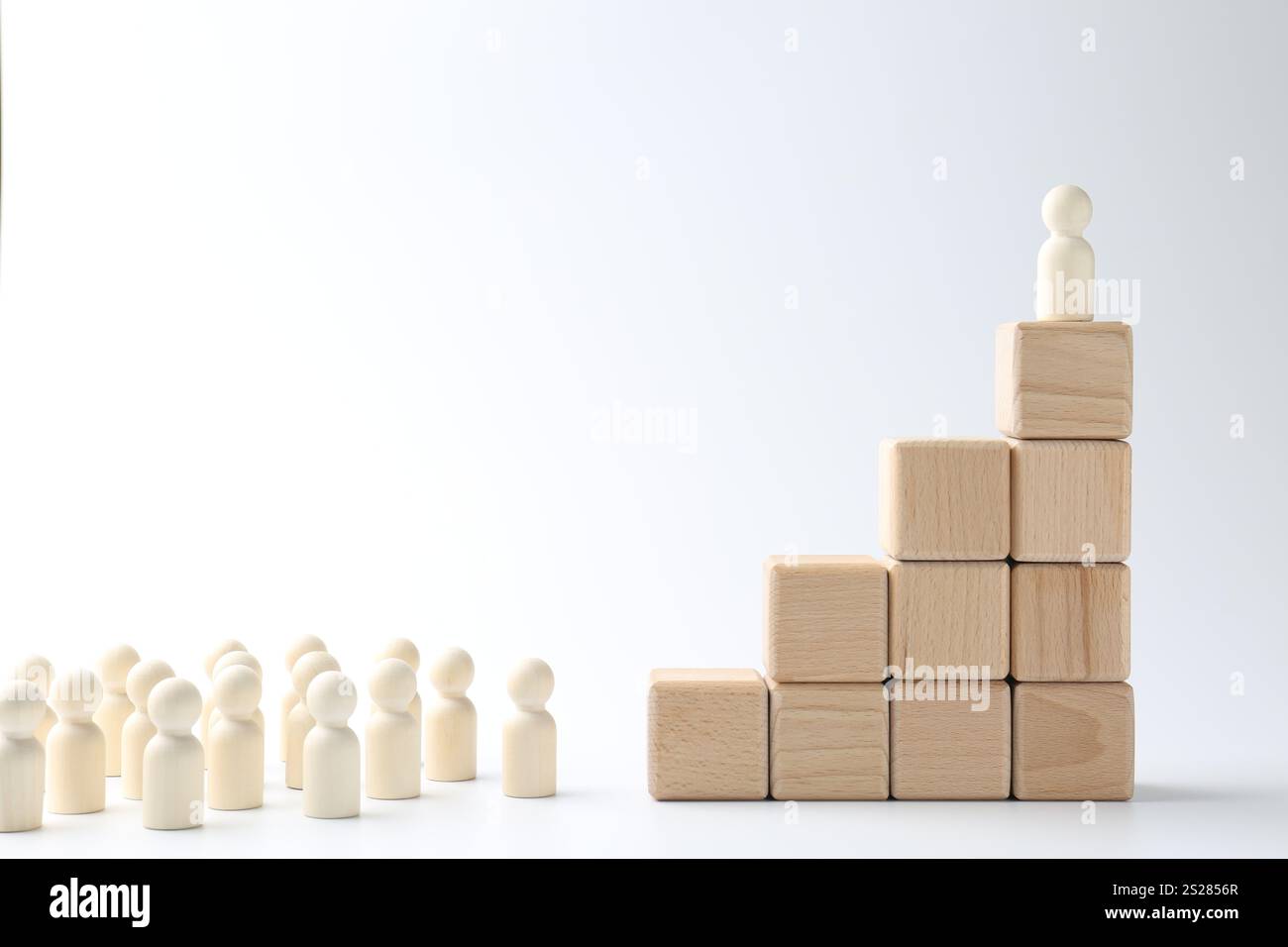 Human figures in front of stacked wooden blocks with one figure on top ...