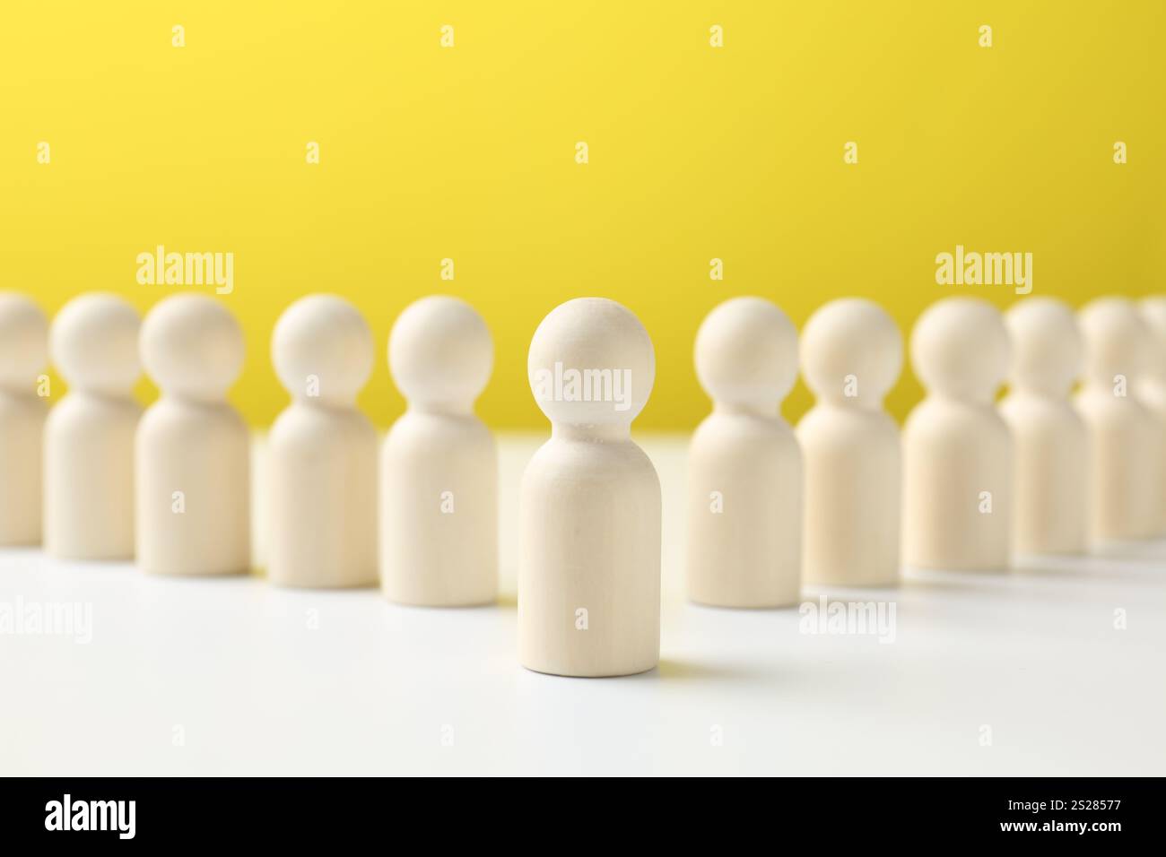 One human figure standing out among others on white table against ...