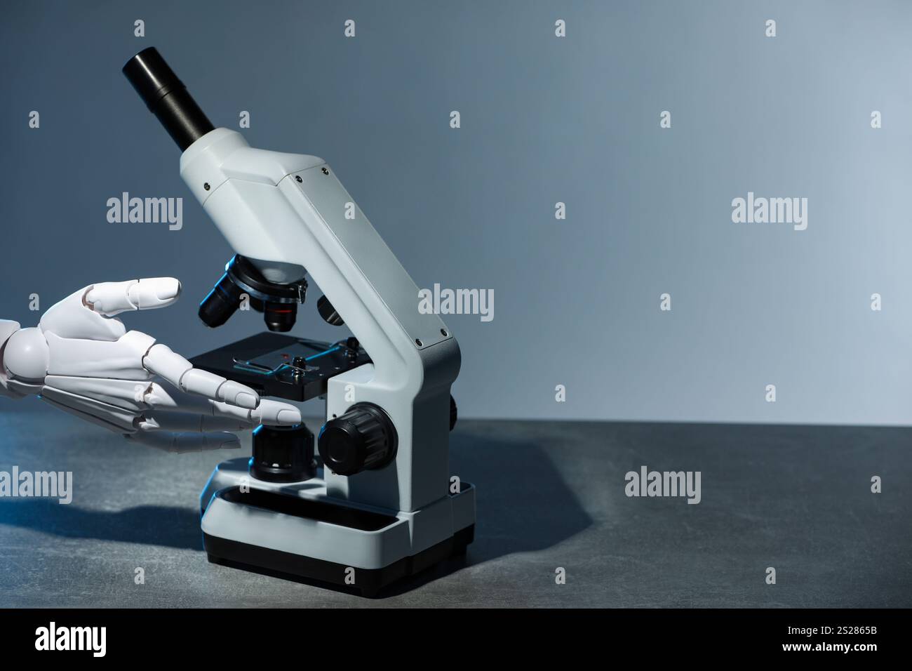Artificial intelligence. Robot hand working with microscope at table ...