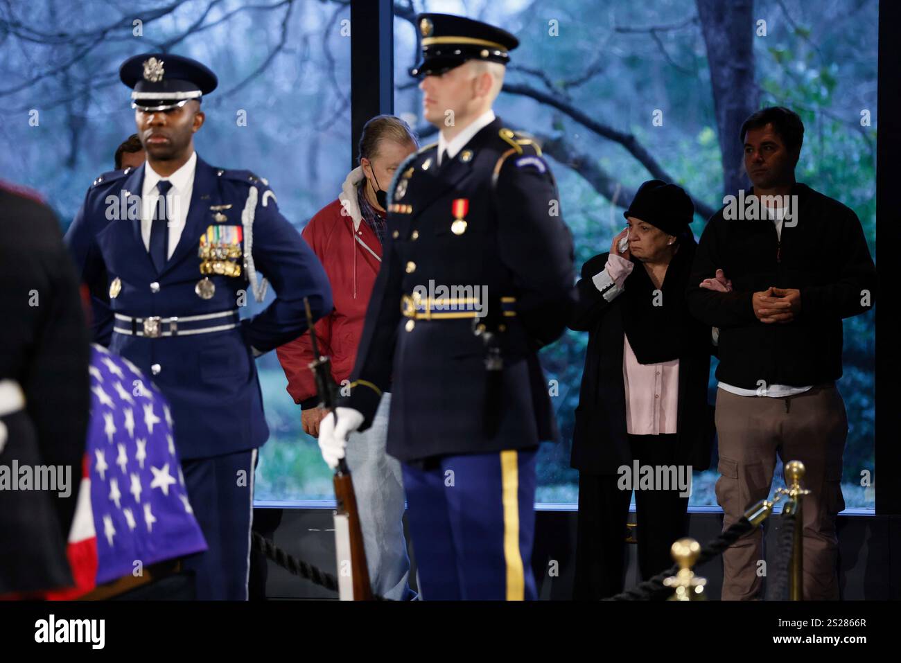 Members of the joint services military honor guard stand by the casket bearing the remains of ...