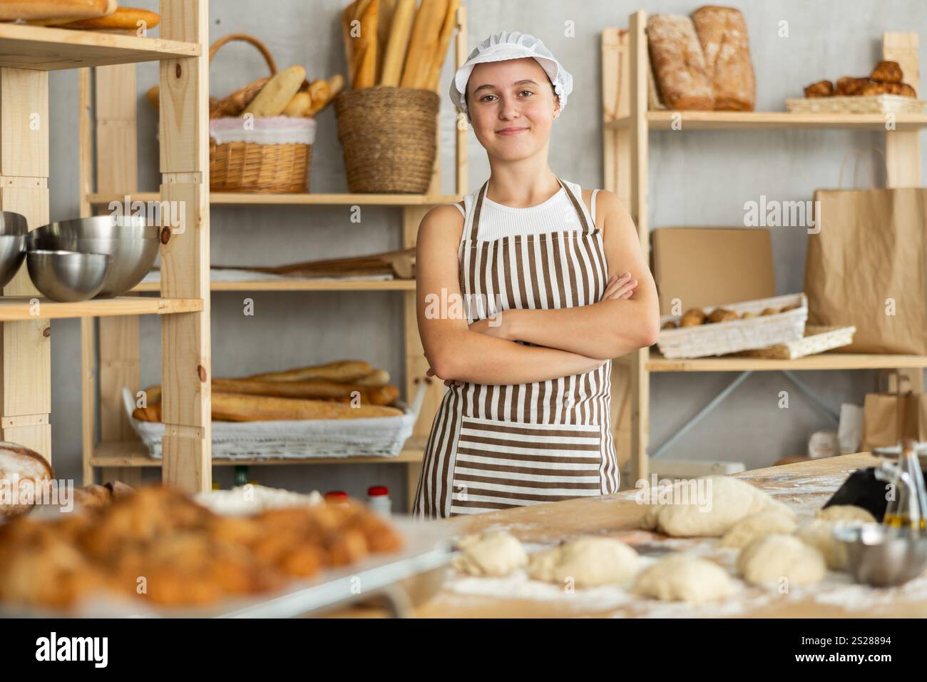 Teenage girl standing in bakehouse, ready to start baking Stock Photo ...