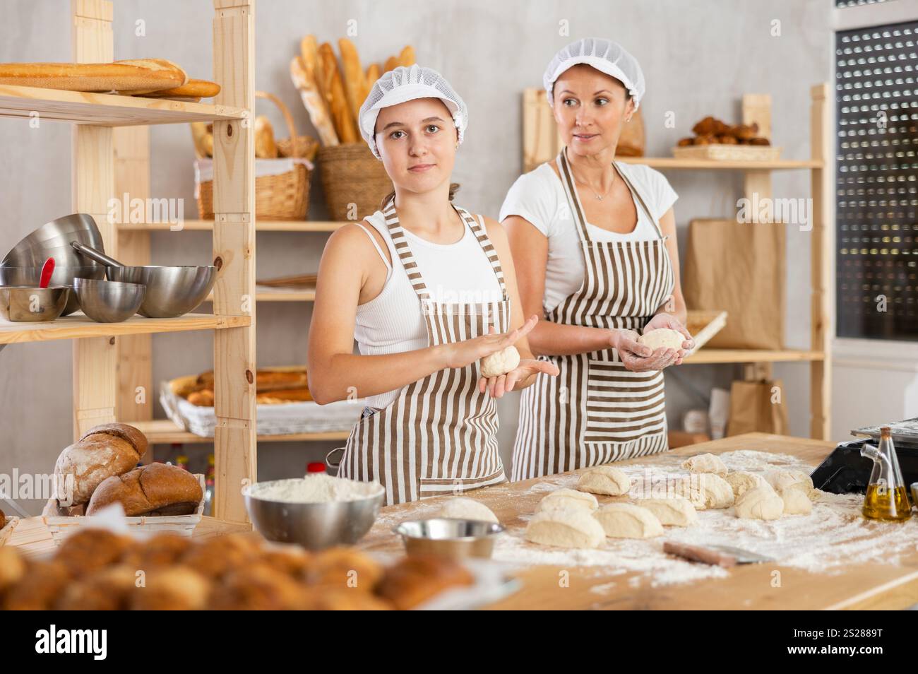 Two bakers working with pieces of dough Stock Photo - Alamy