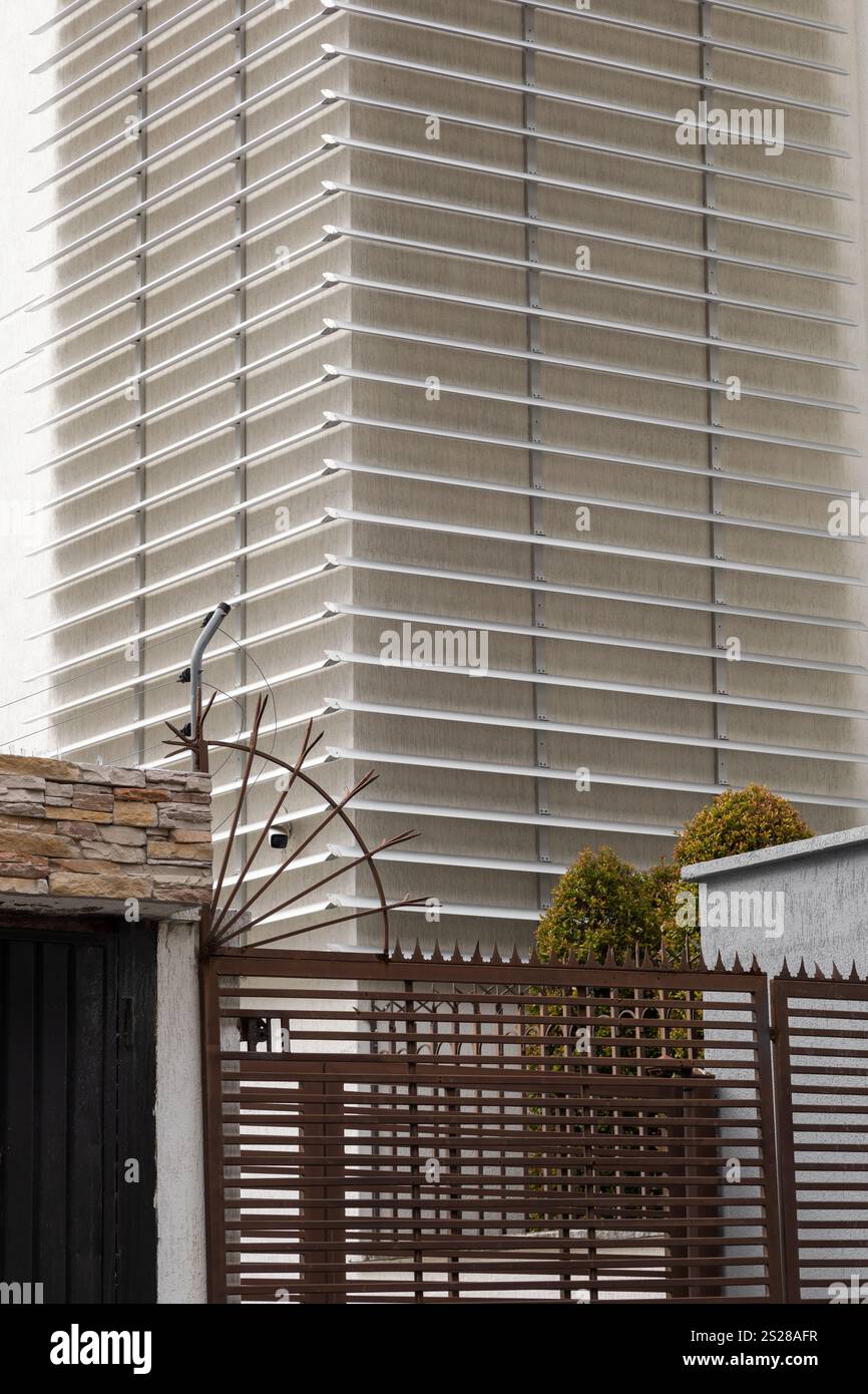 A tall, modern white building with sleek architectural design against a ...