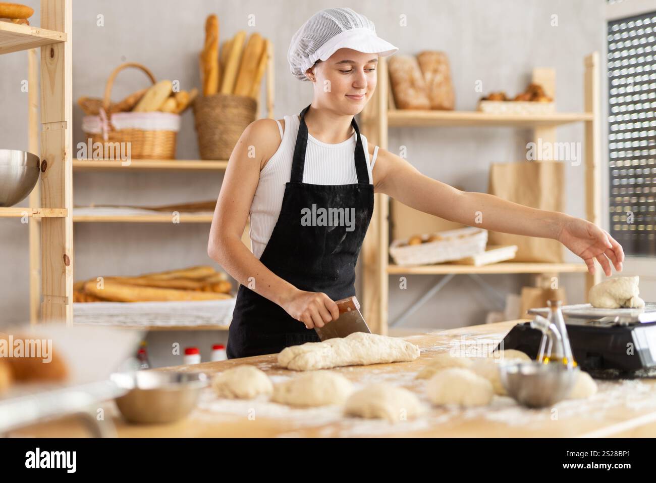 Teenage girl baker cuts and weighs pieces of dough Stock Photo - Alamy