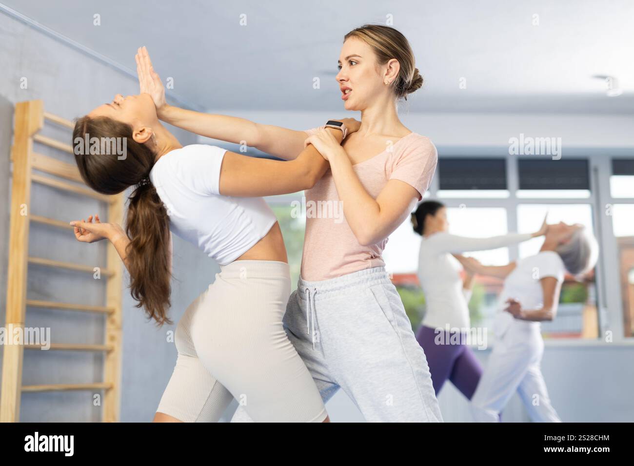 Woman doing a head kick during self defense training Stock Photo - Alamy