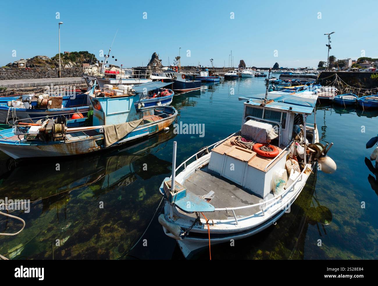 Aci Trezza Marina dei Ciclopi boats harbor. Lachea Island on Cyclopean ...