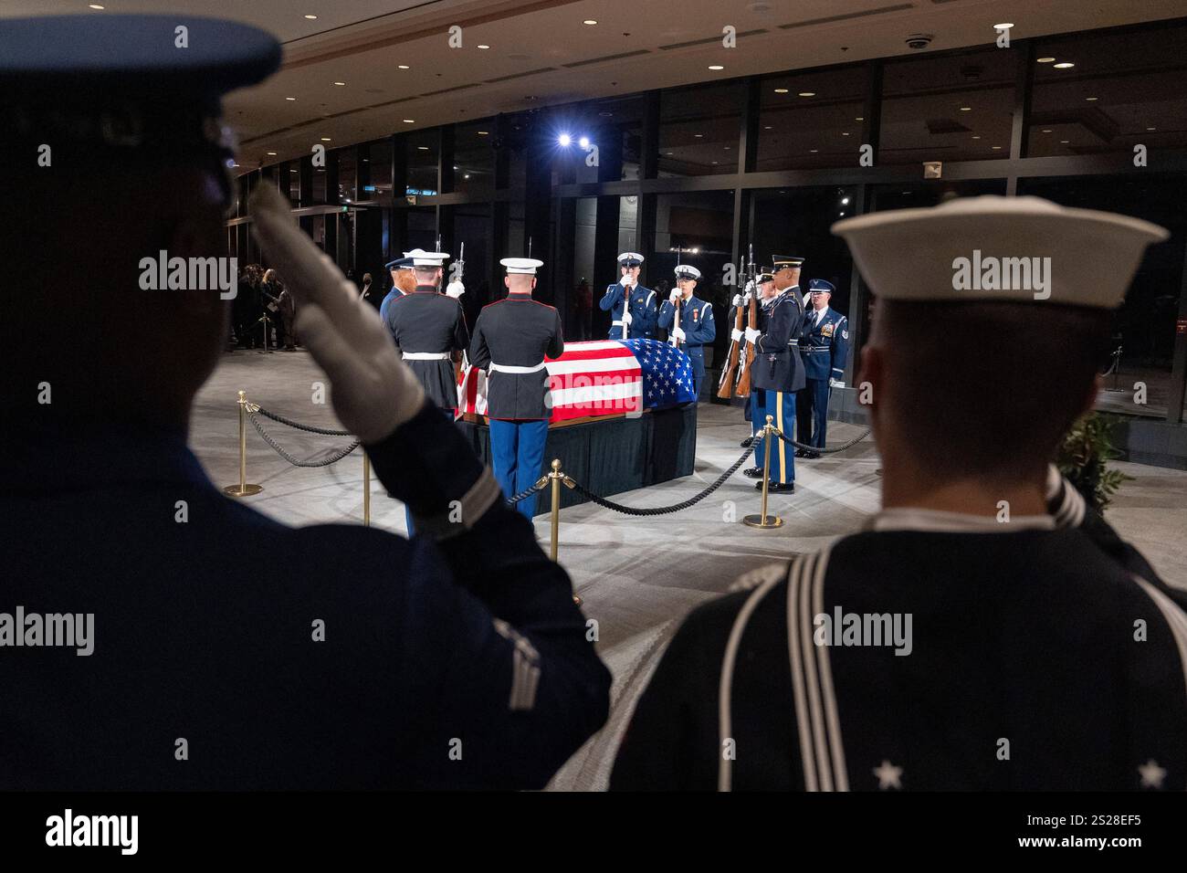 Members of the joint services military honor guard salute during the changing of the guard as ...