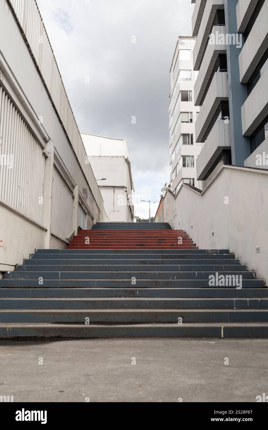 Urban stairs ascending through a cityscape, leading upwards with a ...
