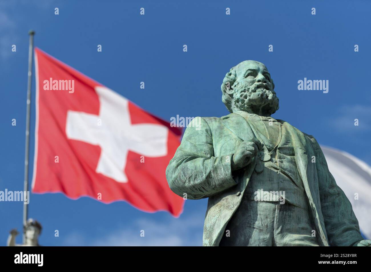 Swiss flag behind monument to Alfred Escher, Swiss politician, business ...