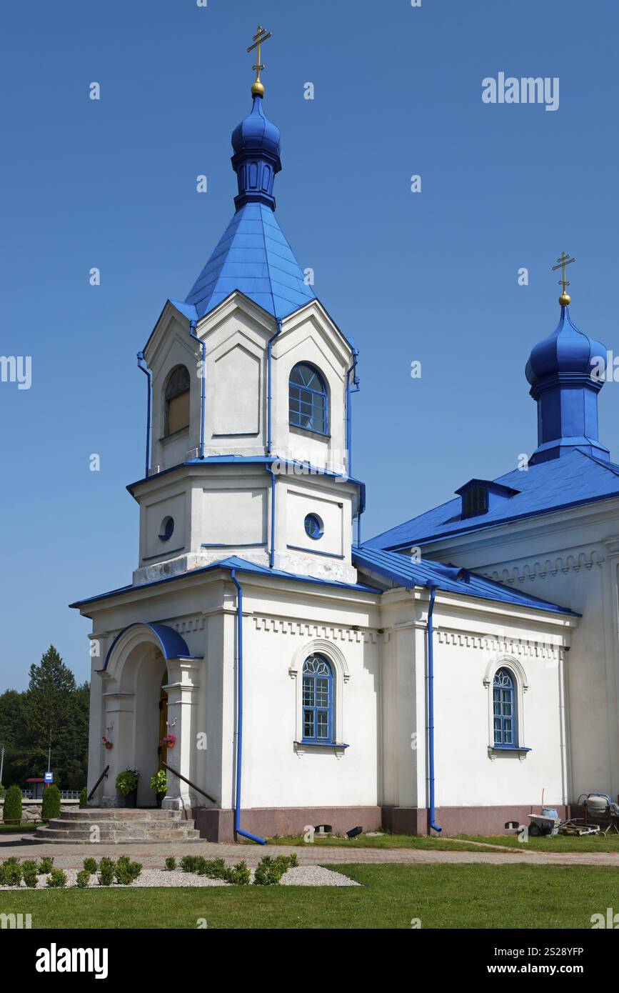 White orthodox church with a striking blue roof, surrounded by nature ...