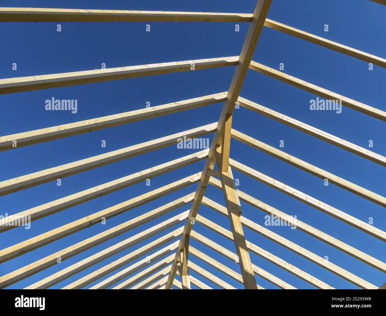 A new roof is being built on a house on a building site. Wooden beams ...