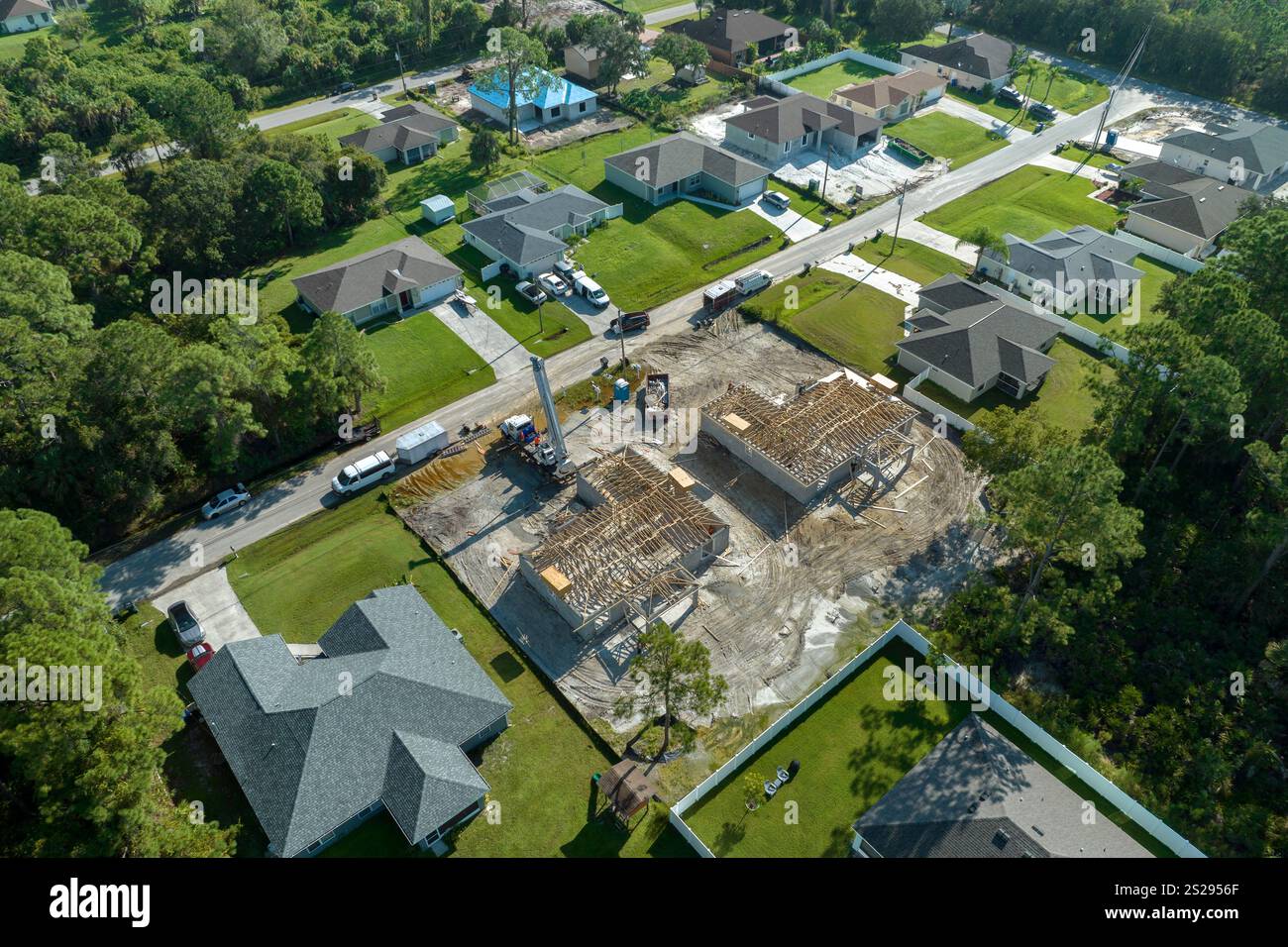 Builders working on roof construction of unfinished residential house ...