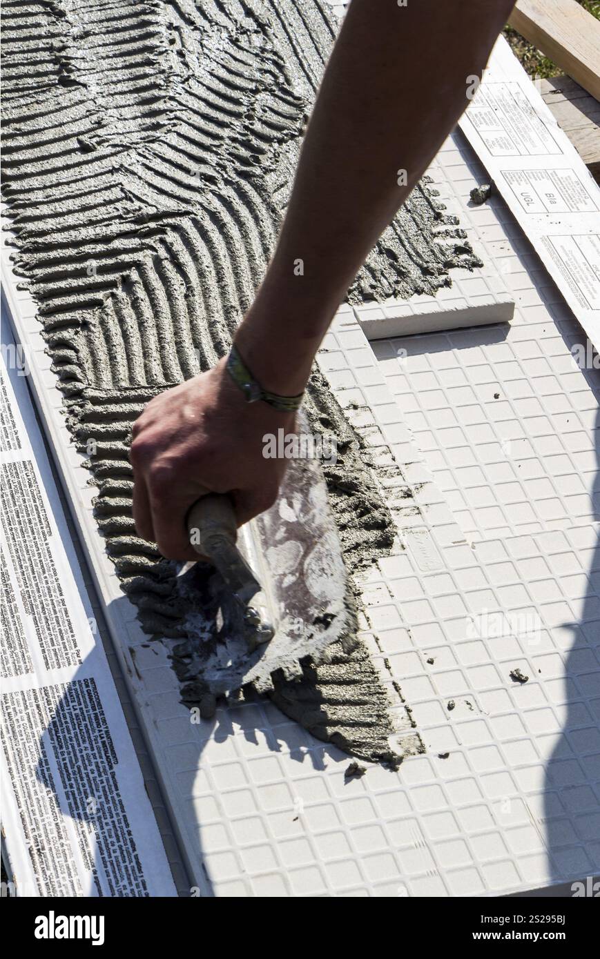Tiler at work. Tiles are glued. Austria Stock Photo - Alamy