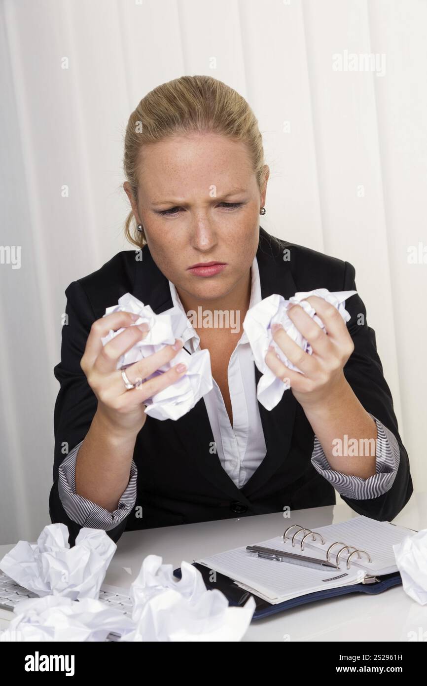 A woman in the office with a ball of paper. Anger, stress and ...