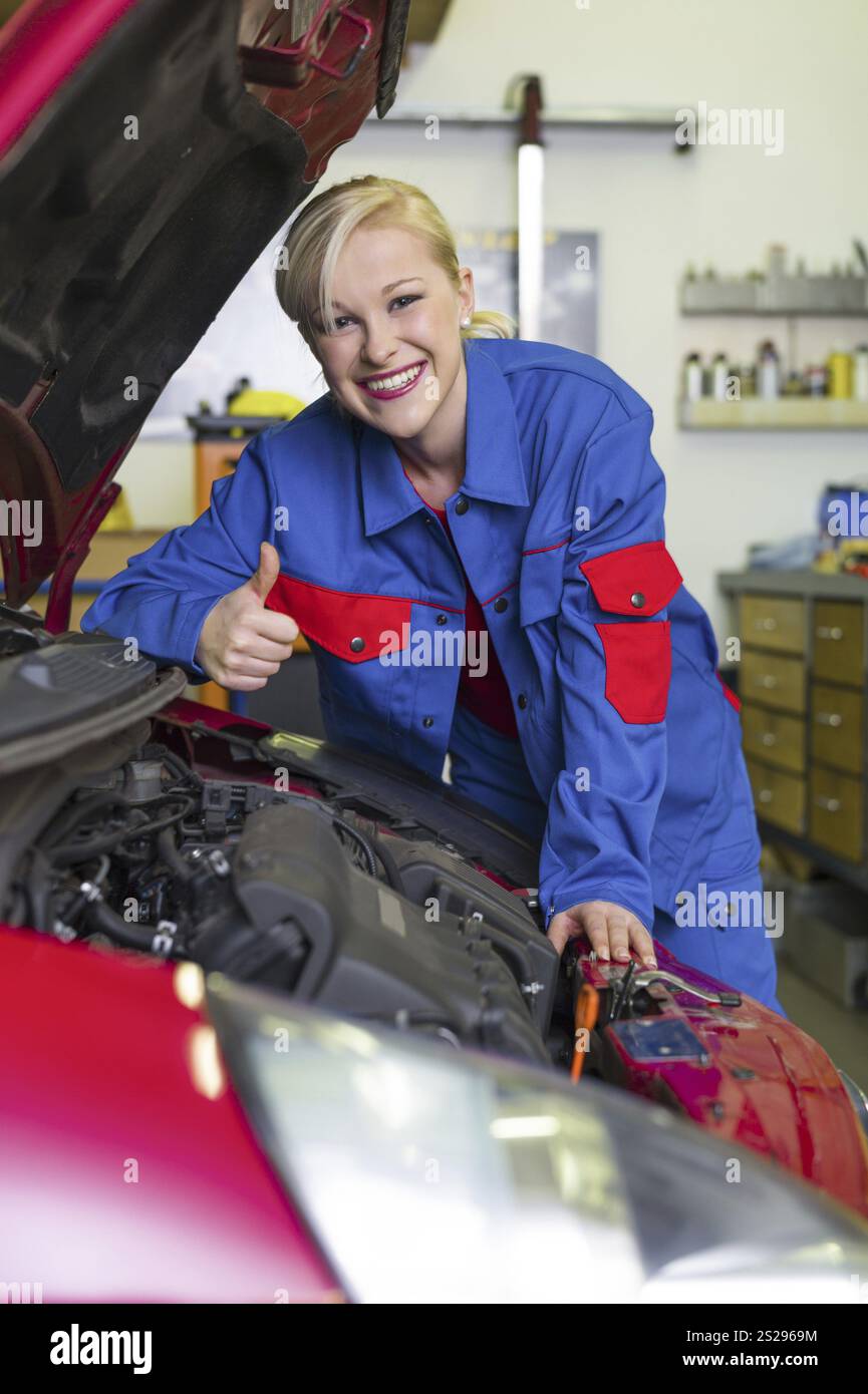 A young woman working as a mechanic in a car repair shop. Rare ...