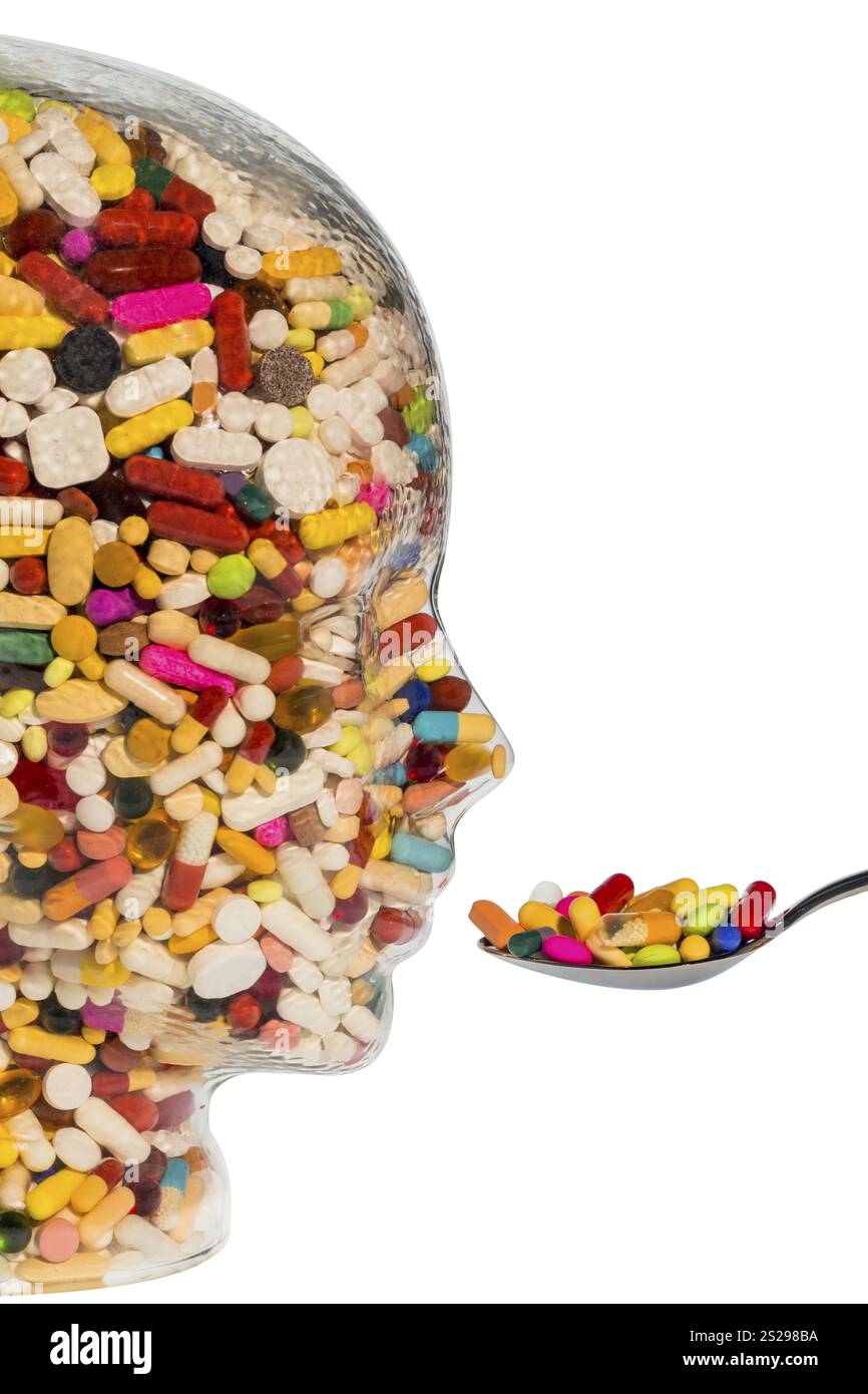 A glass head filled with many tablets. Symbolic photo for medication ...