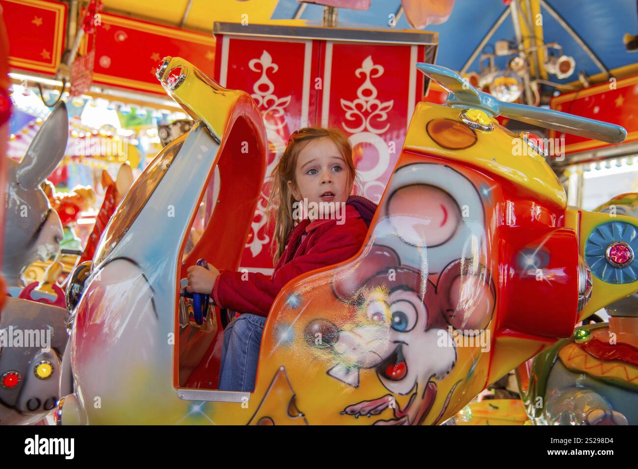 A child rides a merry-go-round at a fair. Friend and fun Austria Stock ...