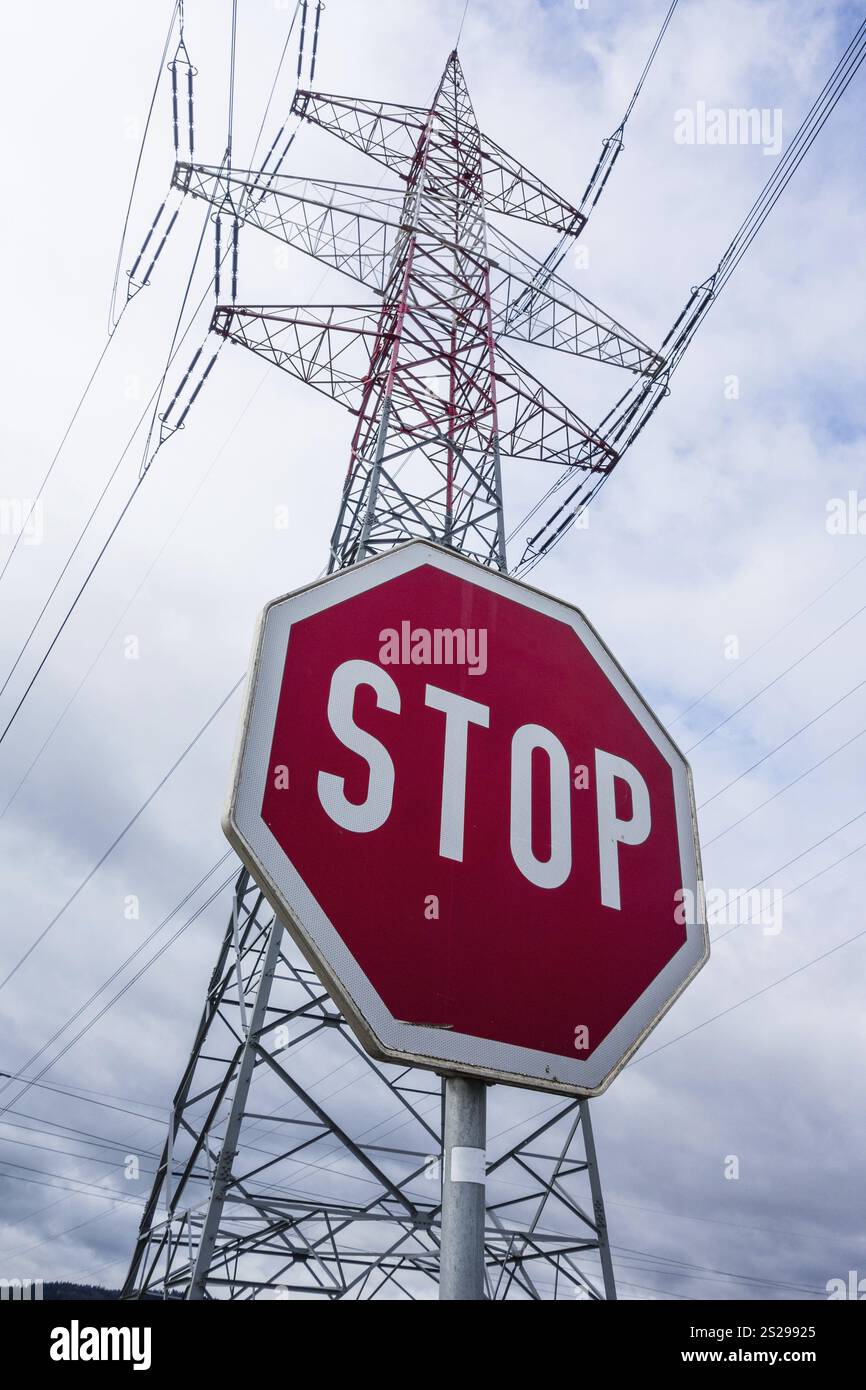 A pylon of a power line and a stop sign. Symbolic photo for phasing out ...