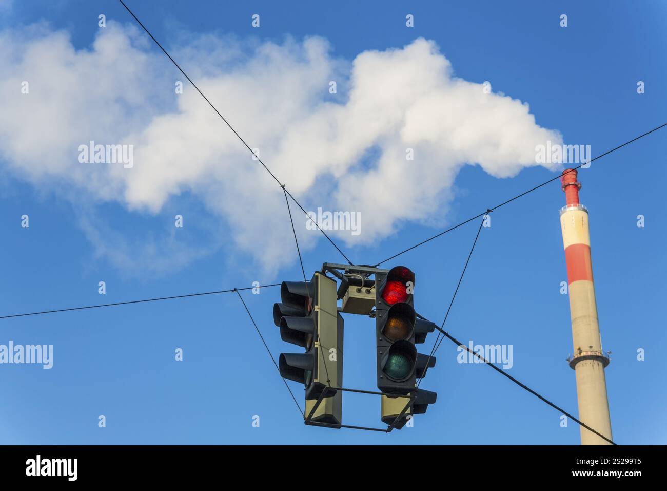 Industrial plant chimney and red traffic light. Symbolic photo for ...