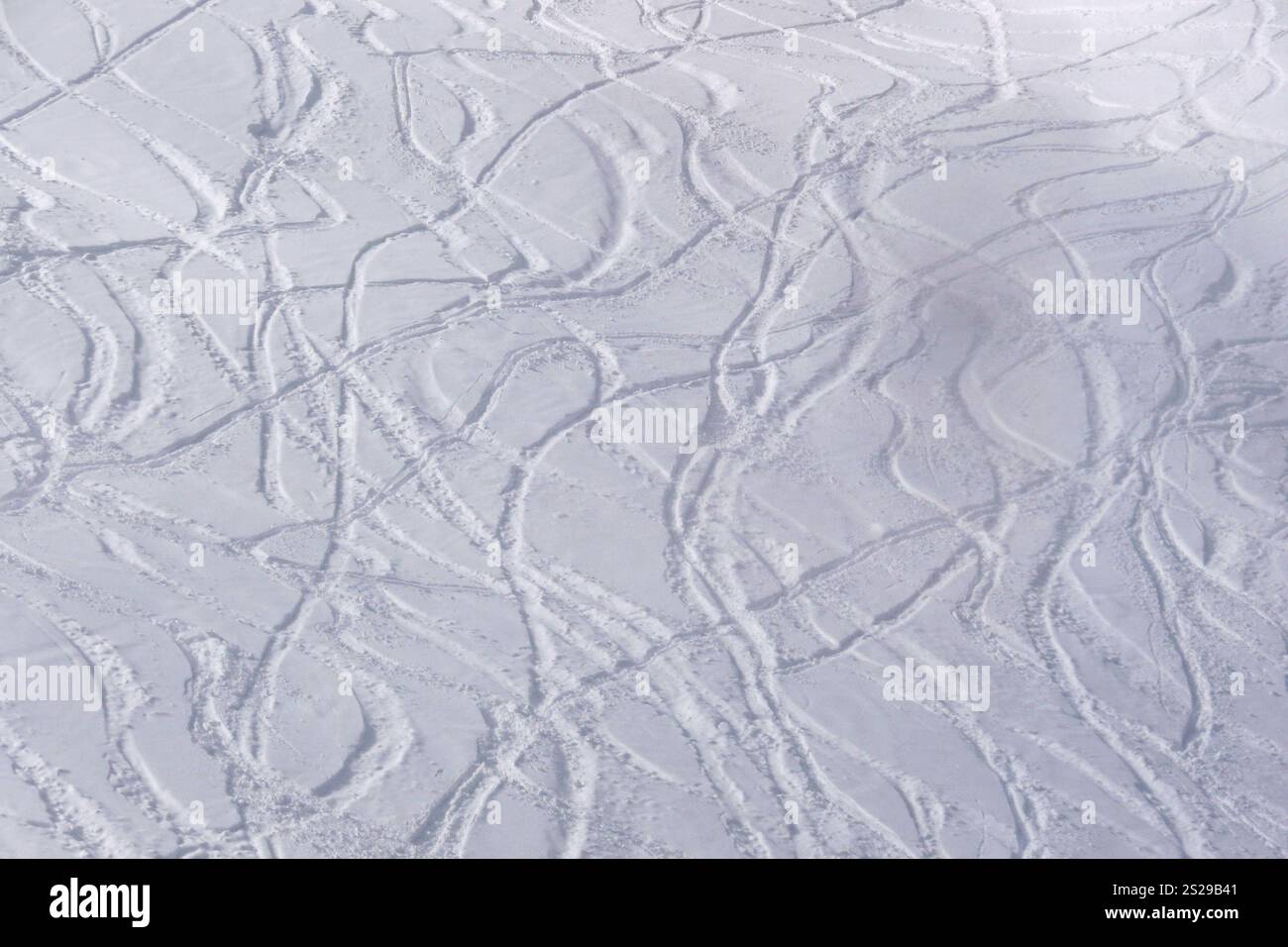 Many tracks from skiers on a slope with snow Stock Photo - Alamy
