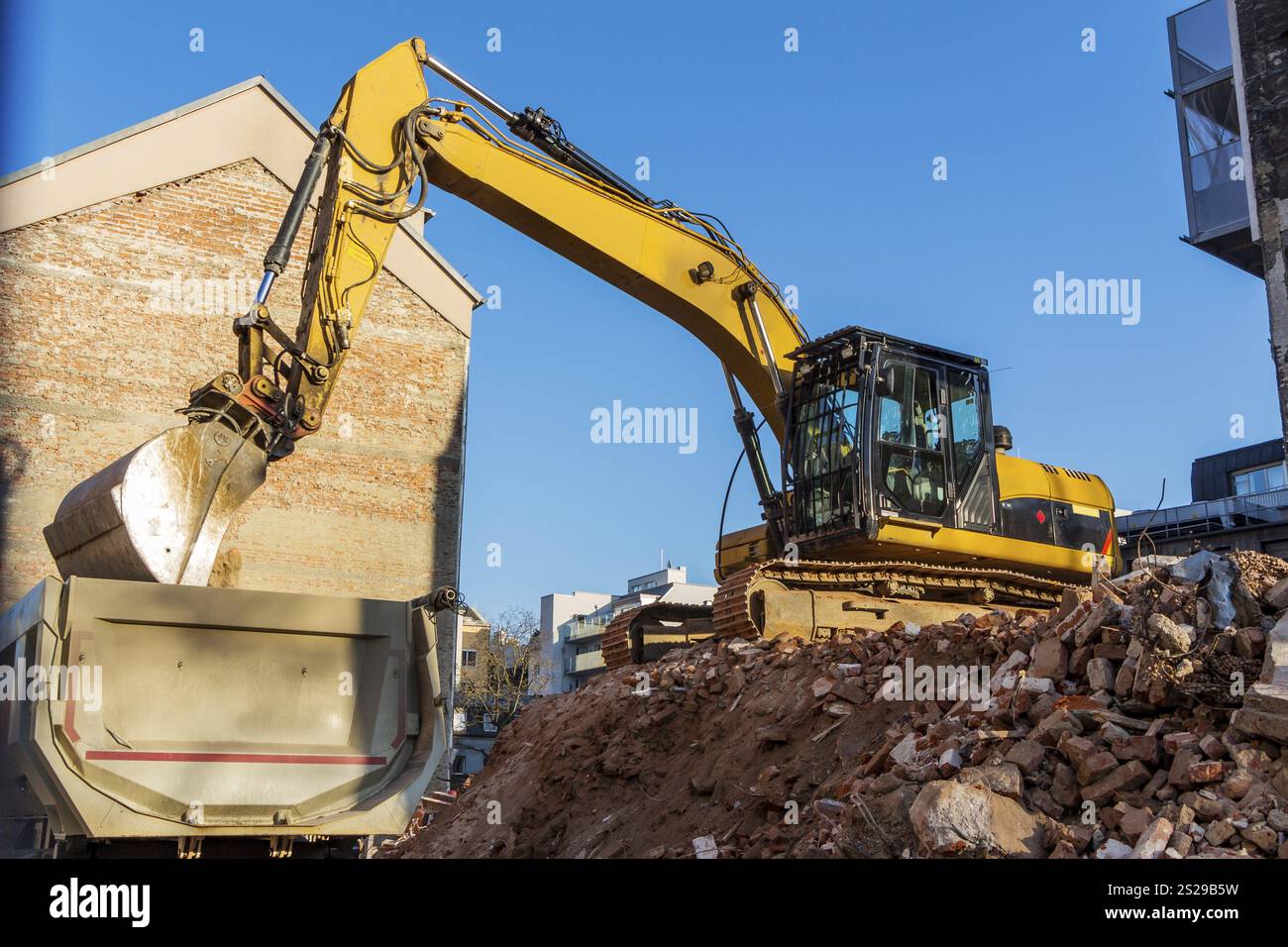 Excavators on a building site demolishing a house, creating space for ...