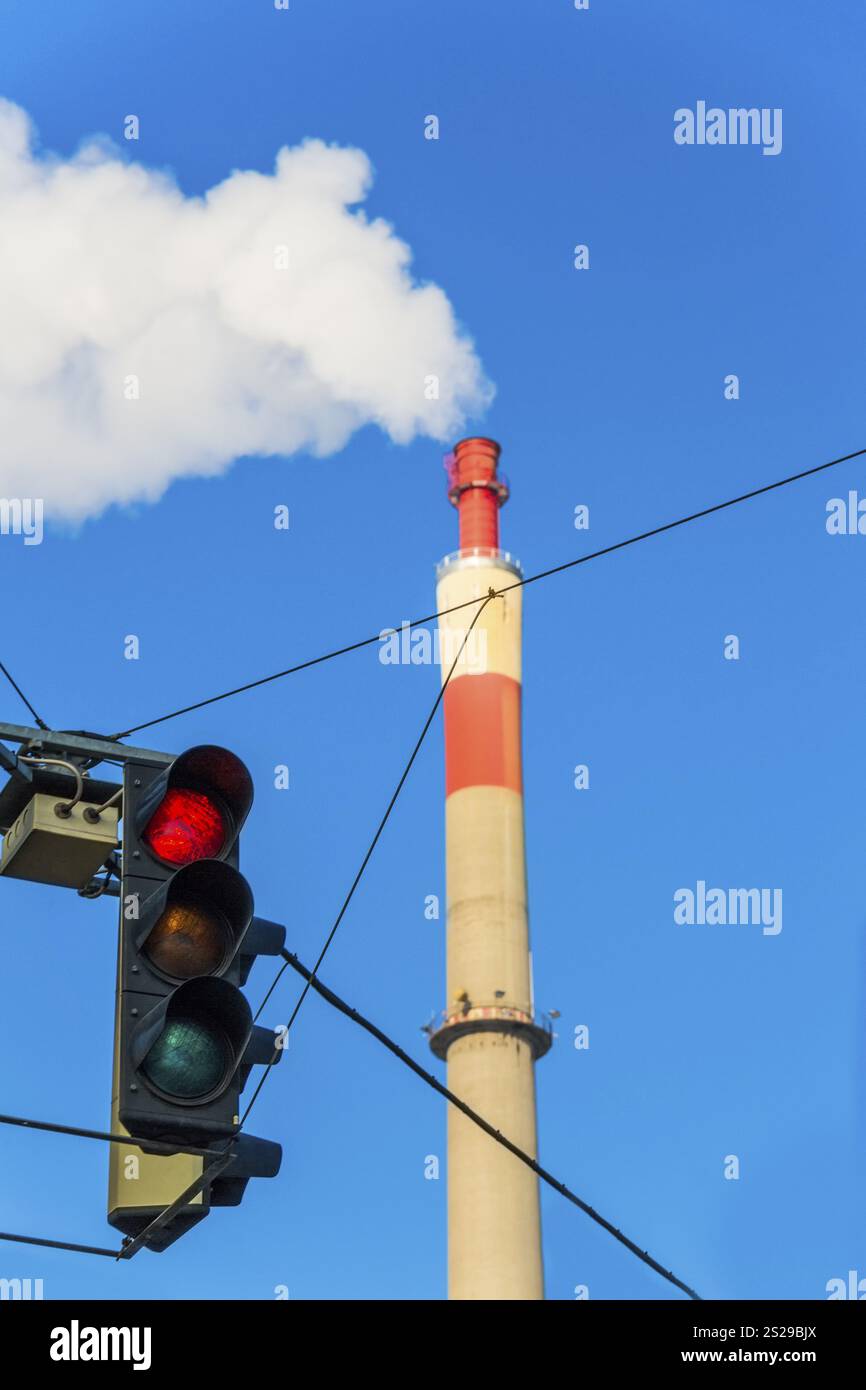 Industrial plant chimney and red traffic light. Symbolic photo for ...