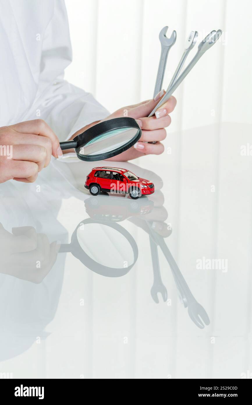 A model of a car is examined by a doctor. Symbol photo for workshop ...