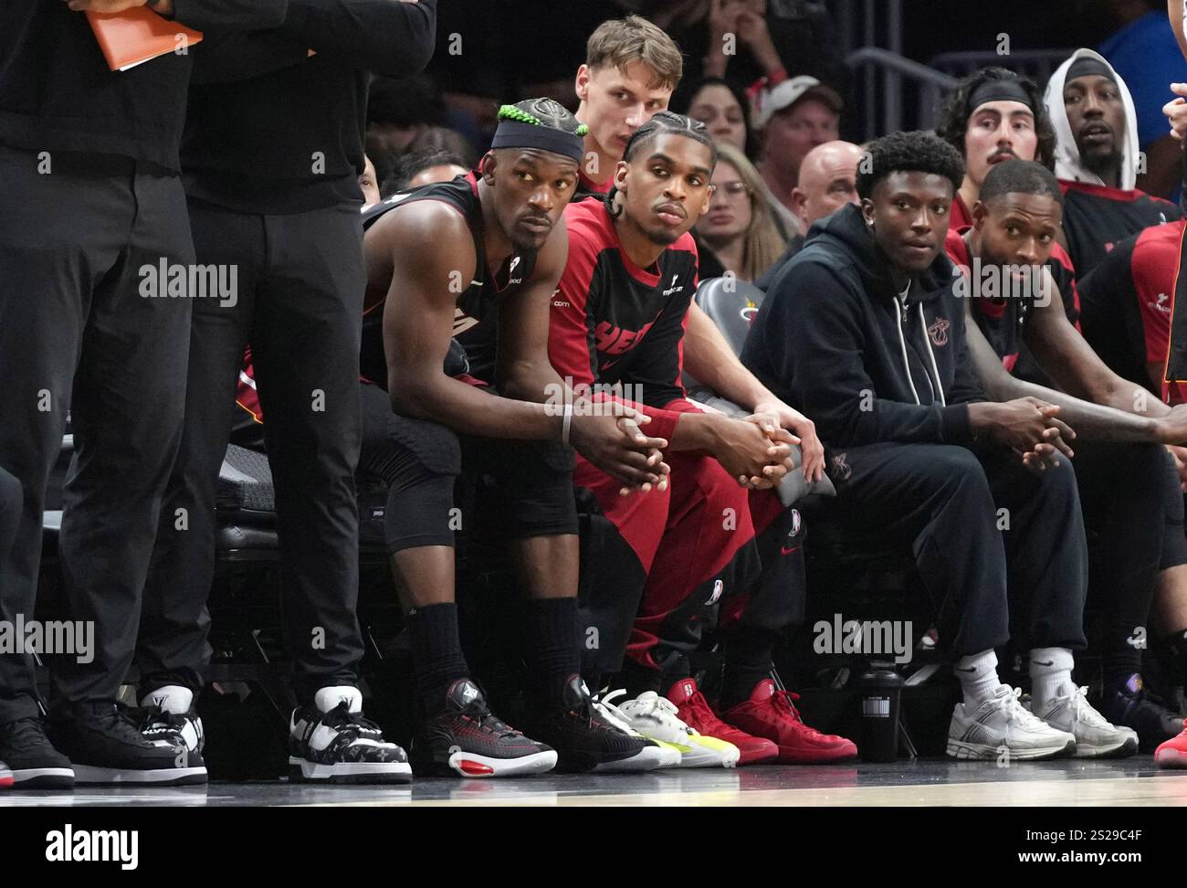 Miami Heat forward Jimmy Butler, left, seated, watches from the bench ...