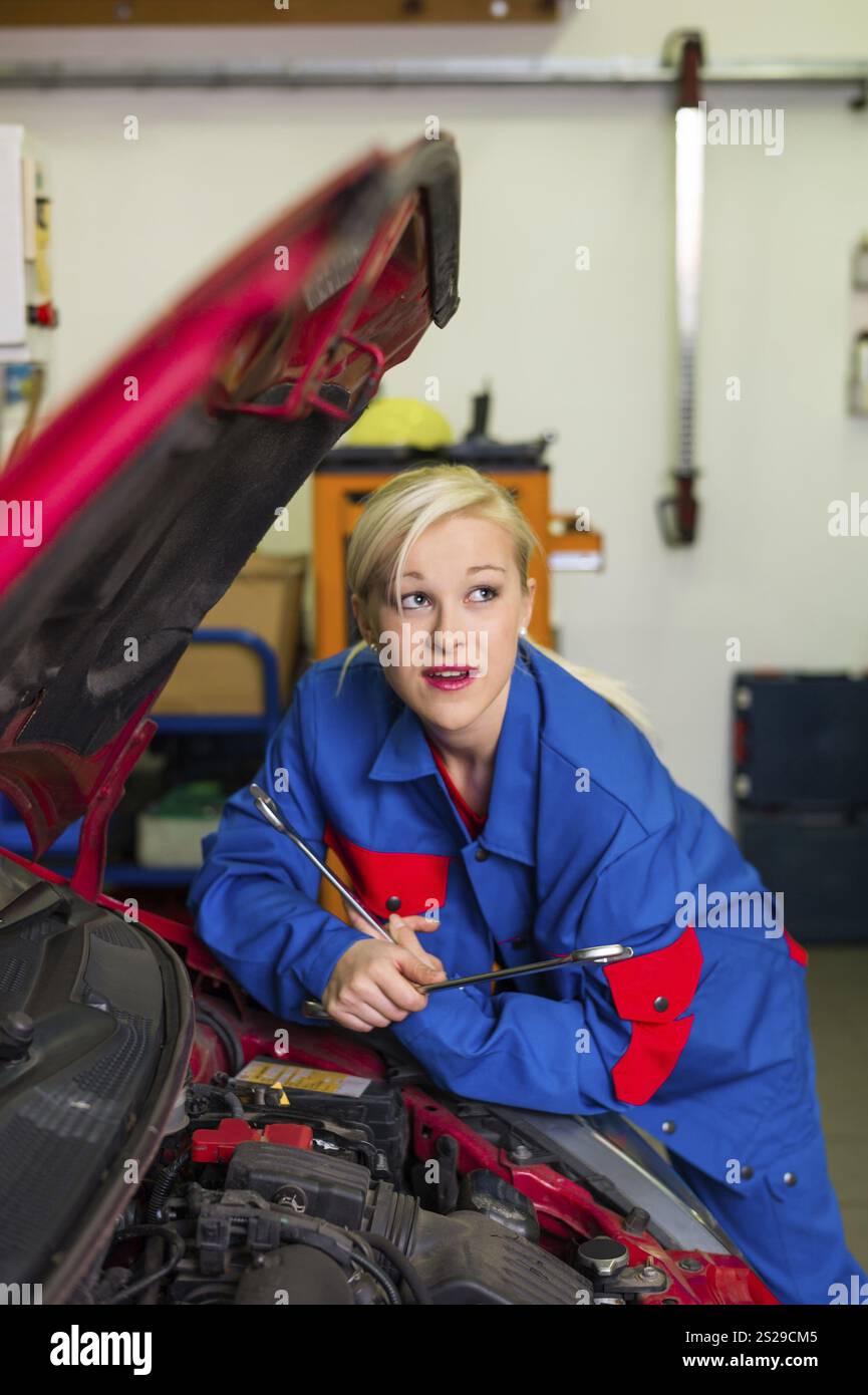 A young woman working as a mechanic in a car repair shop. Rare ...