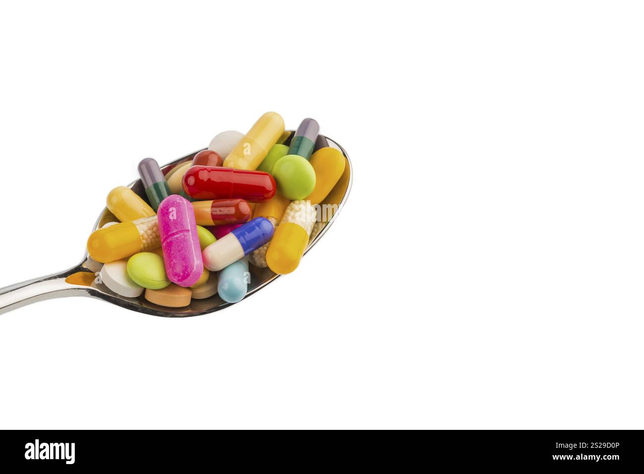 Many colourful tablets on a spoon. Symbolic photo for tablet addiction ...