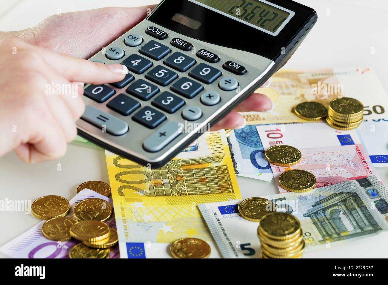 Hand with calculator and banknotes. Symbol photo for turnover, profit ...