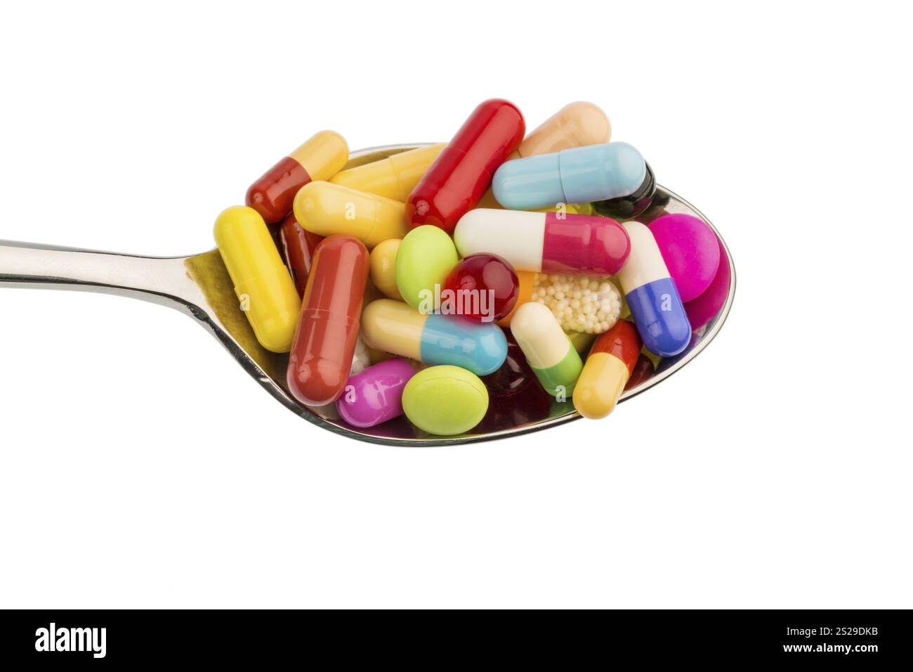 Many colourful tablets on a spoon. Symbolic photo for tablet addiction ...