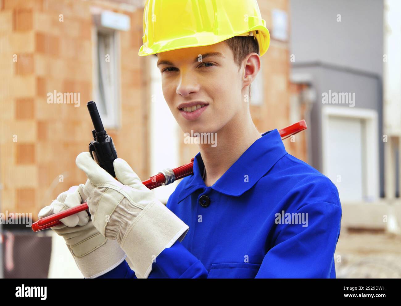 An apprentice / trainee. Construction worker on building site with ...