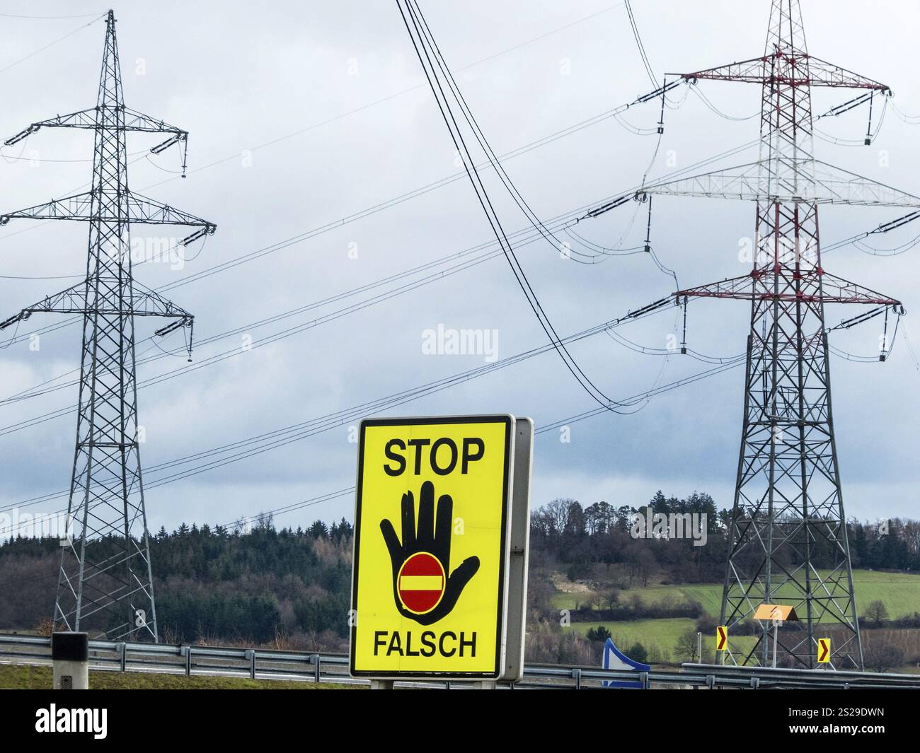 A pylon of a power line and a stop sign. Symbolic photo for phasing out ...