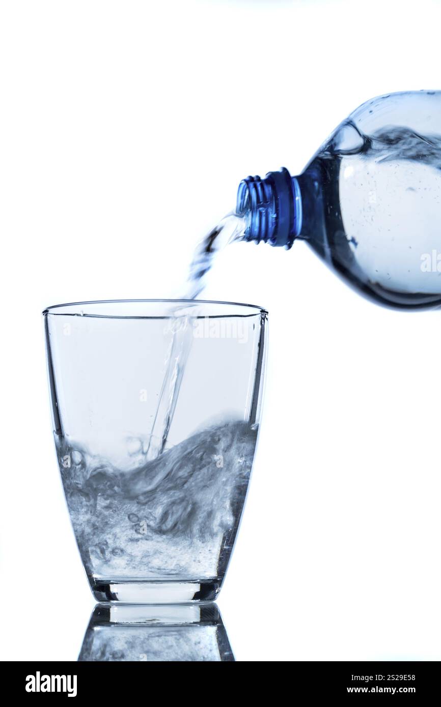 Water is poured from a water bottle into a glass Stock Photo - Alamy