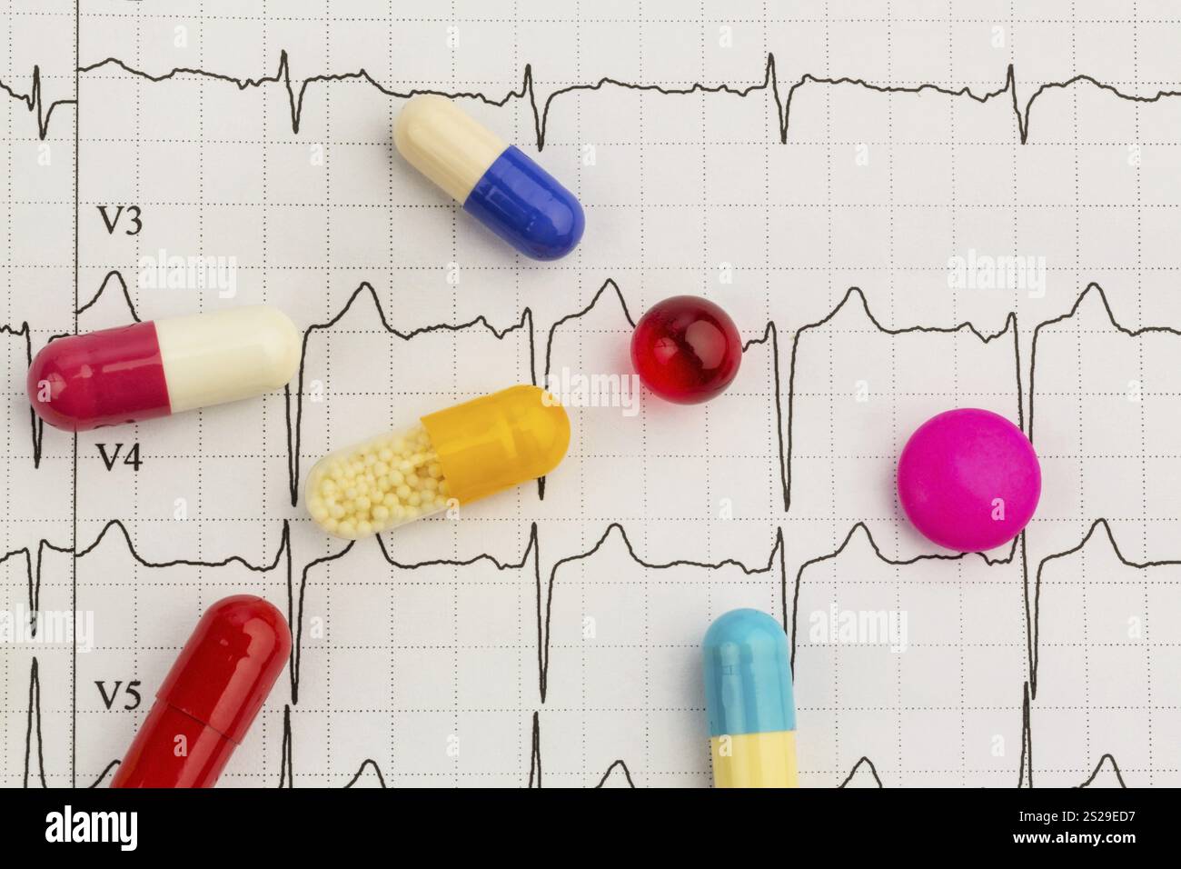 Several tablets lie on an ECG. Symbolic photo for diseases of the heart ...