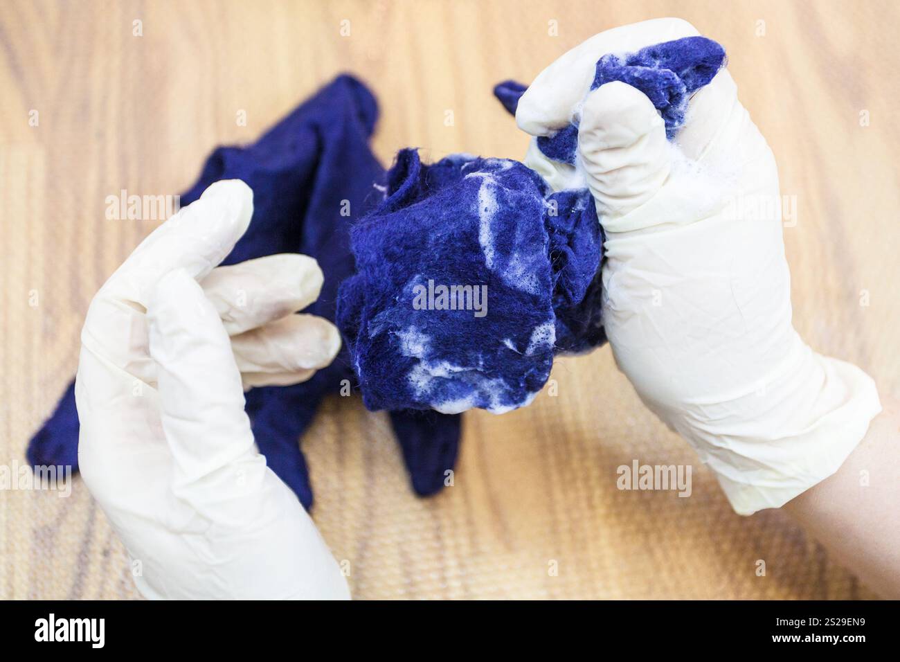 workshop of hand making a fleece gloves from blue Merino sheep wool ...