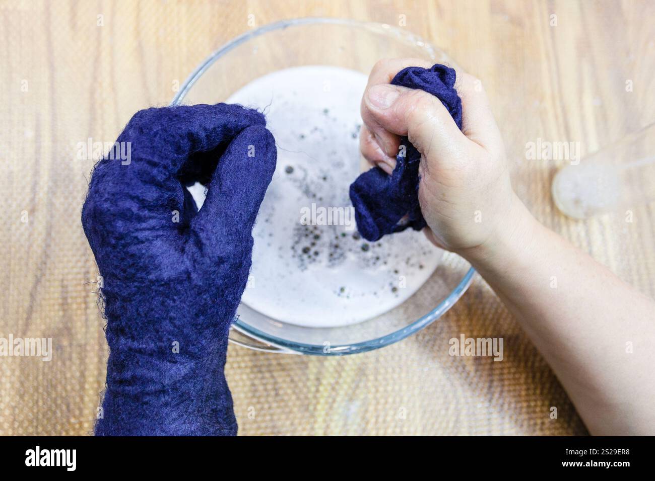 workshop of hand making a fleece gloves from blue Merino sheep wool ...