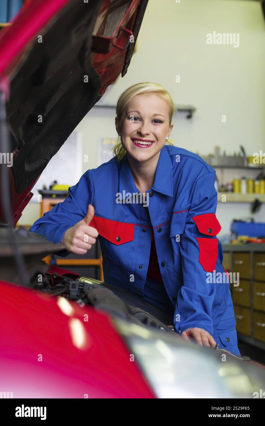 A young woman working as a mechanic in a car repair shop. Rare ...