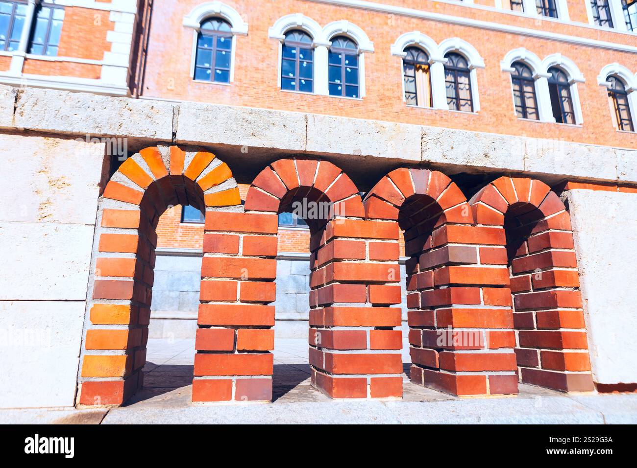 Brick structure with four arched openings, set against backdrop of ...
