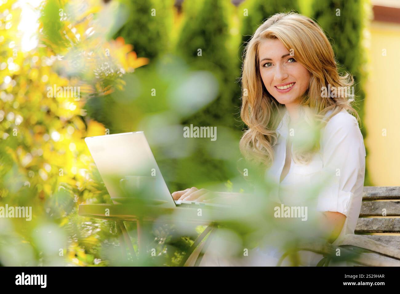 Woman with laptop in the garden Stock Photo - Alamy