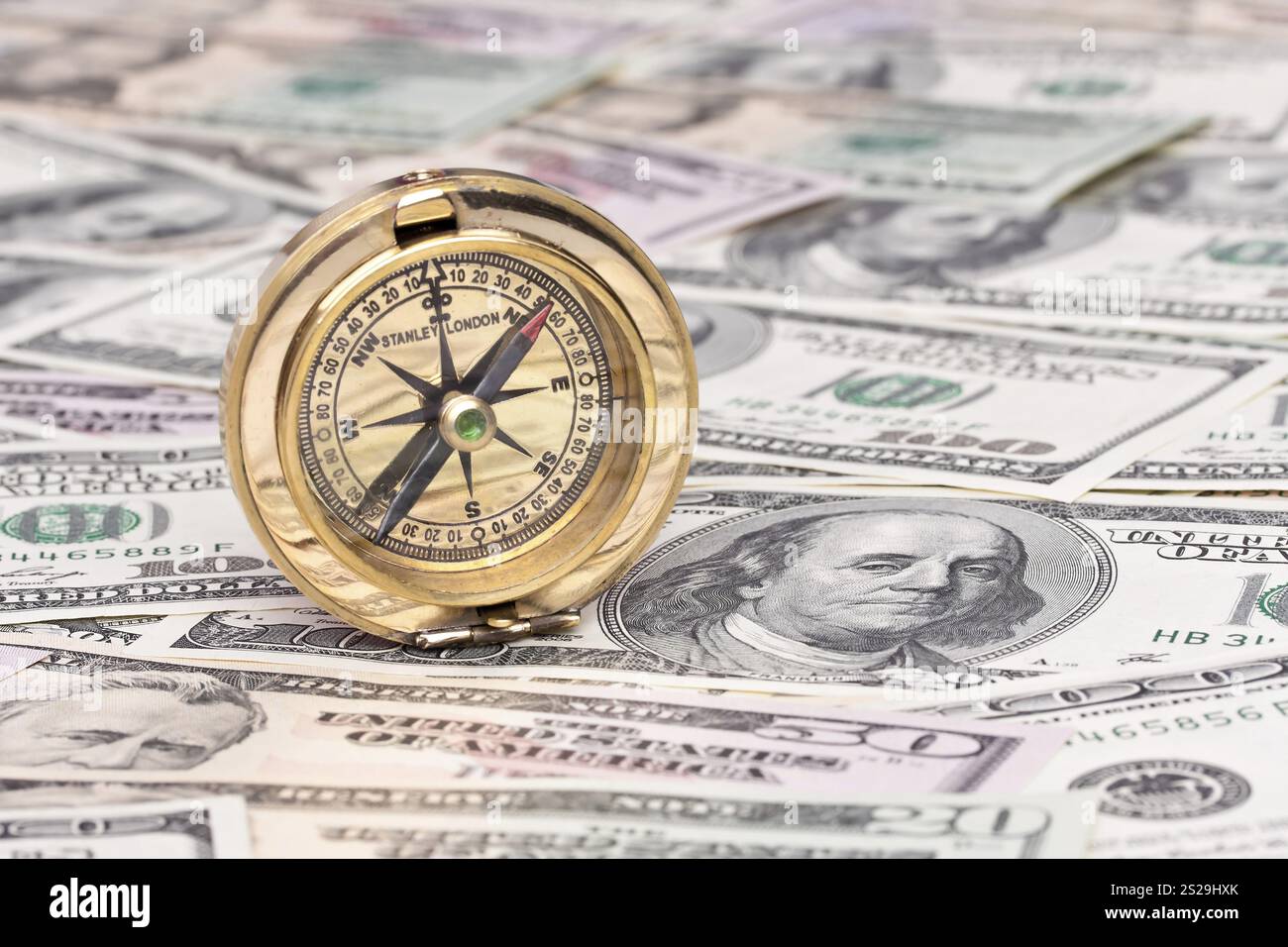 Many dollar banknotes and compass Austria Stock Photo - Alamy