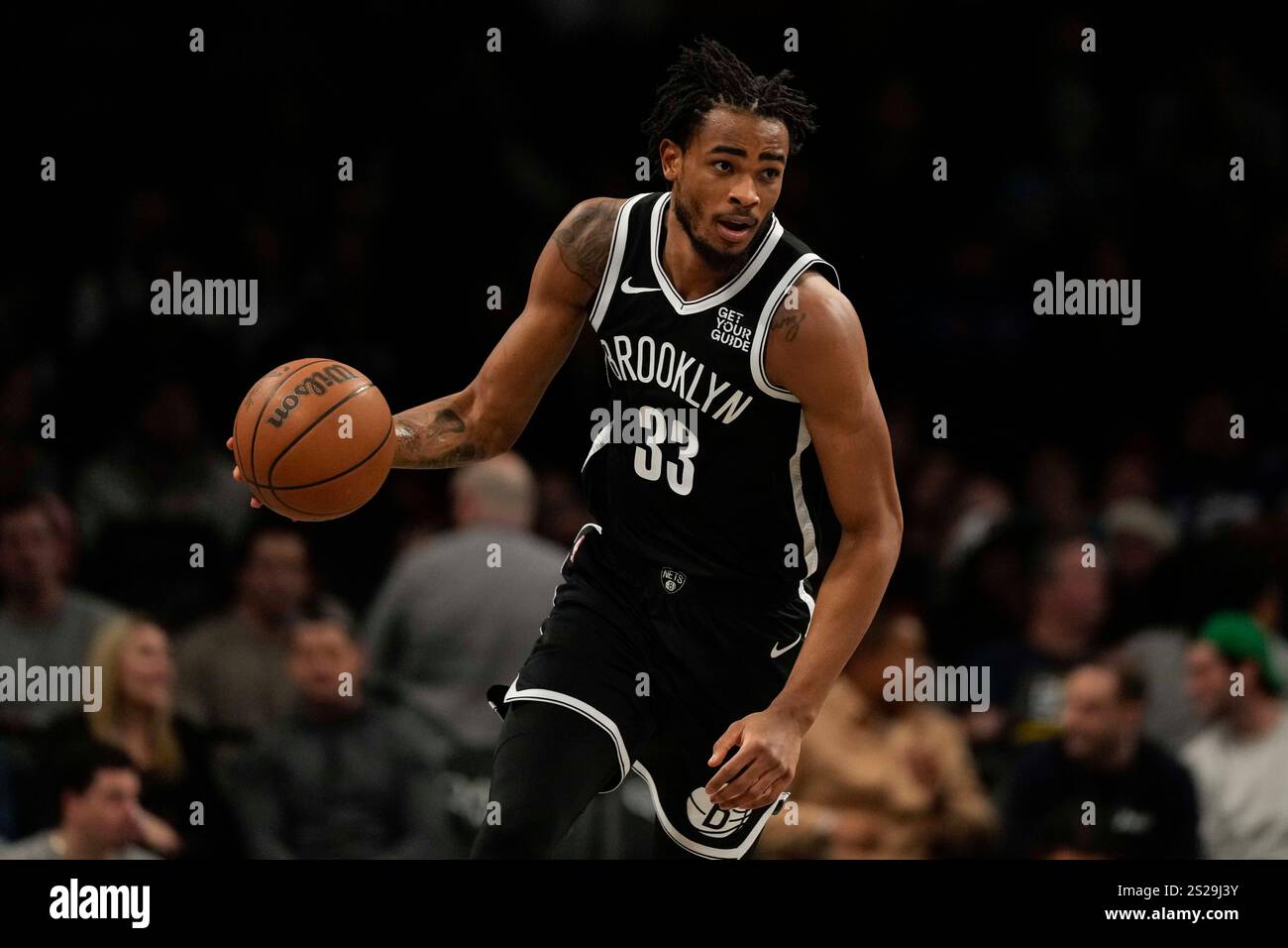 Brooklyn Nets' Nic Claxton (33) looks to pass during the first half of ...