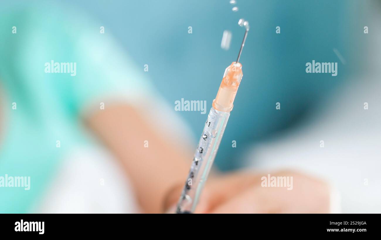 Macro photo of nurse releasing air bubbles from syringe with medictaion ...