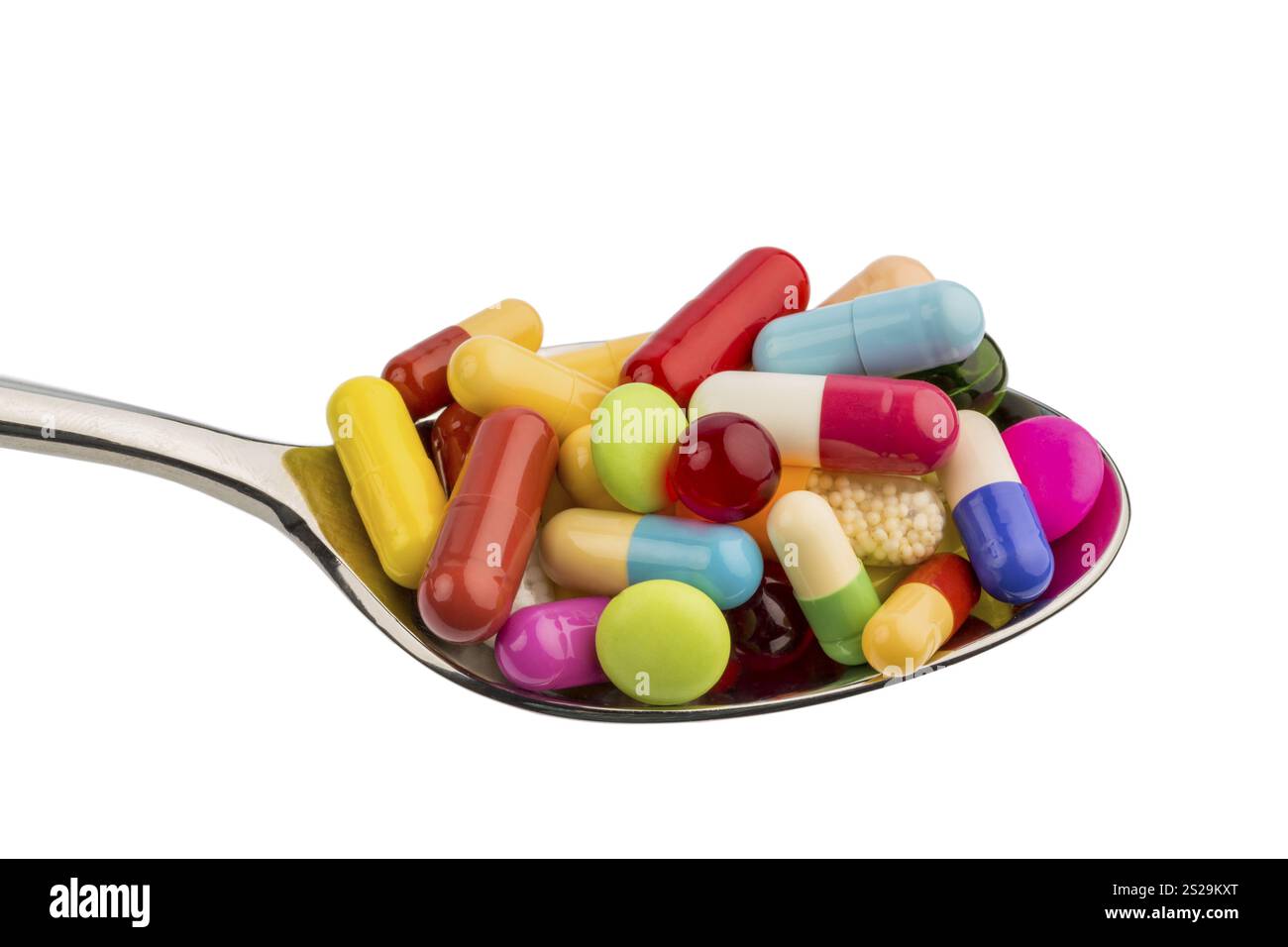 Many colourful tablets on a spoon. Symbolic photo for tablet addiction ...