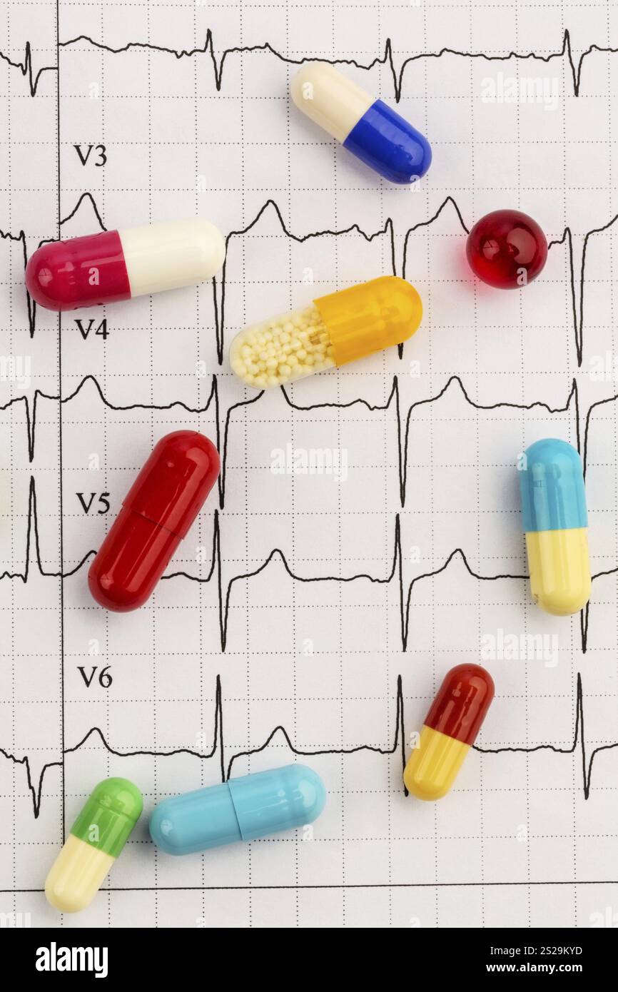 Several tablets lie on an ECG. Symbolic photo for diseases of the heart ...