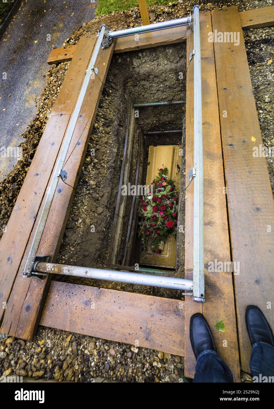 The open, fresh grave with coffin in a cemetery. After the funeral ...